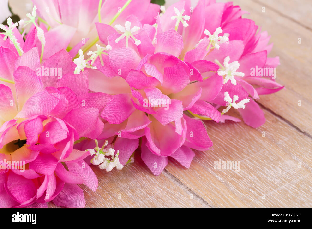 Pink artificial flowers on wooden background, closeup picture Stock ...