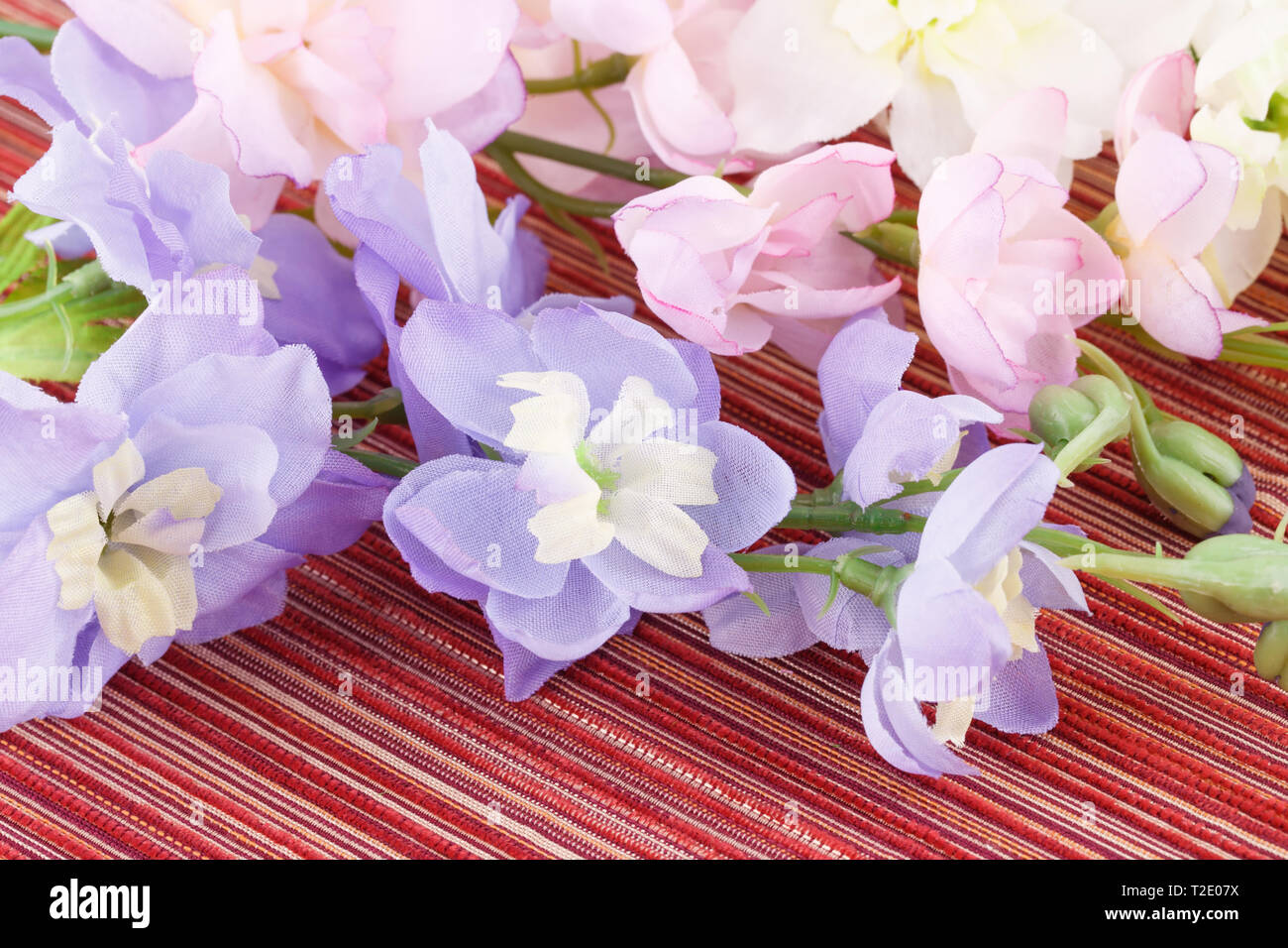 Colorful artificial flowers on cloth background, closeup picture Stock ...