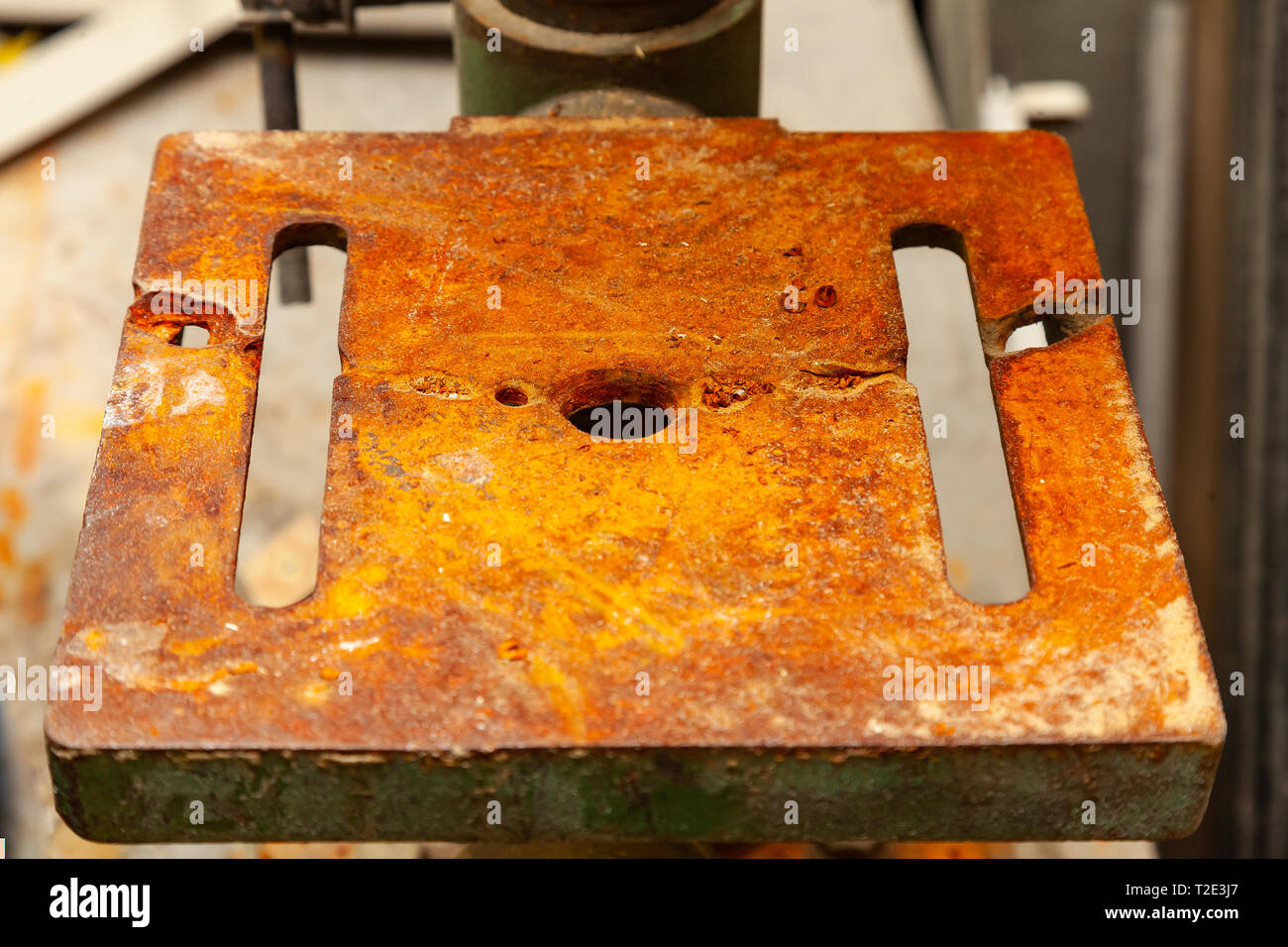 An iron plate with holes covered with a thick layer of rust that eats ...