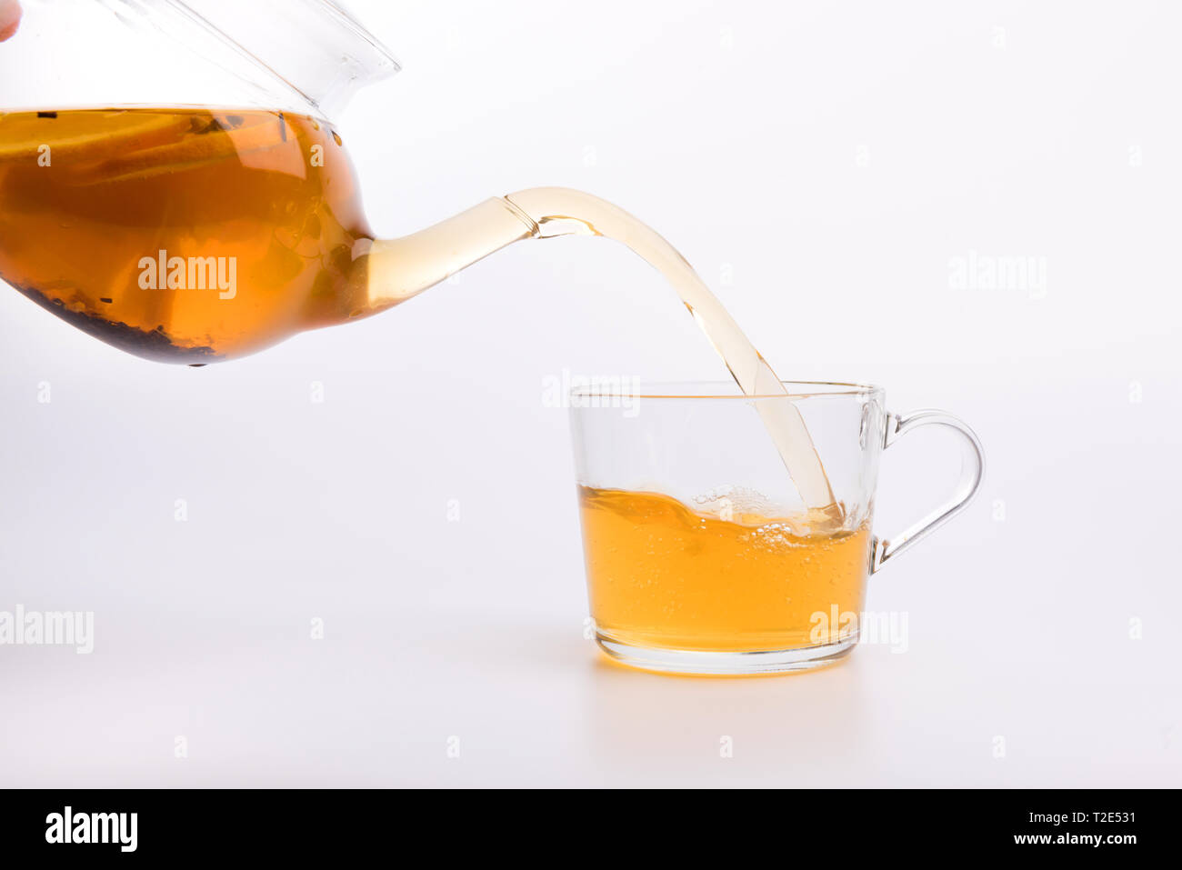 Fruit tea pouring into glass cup Isolated on white background Stock ...