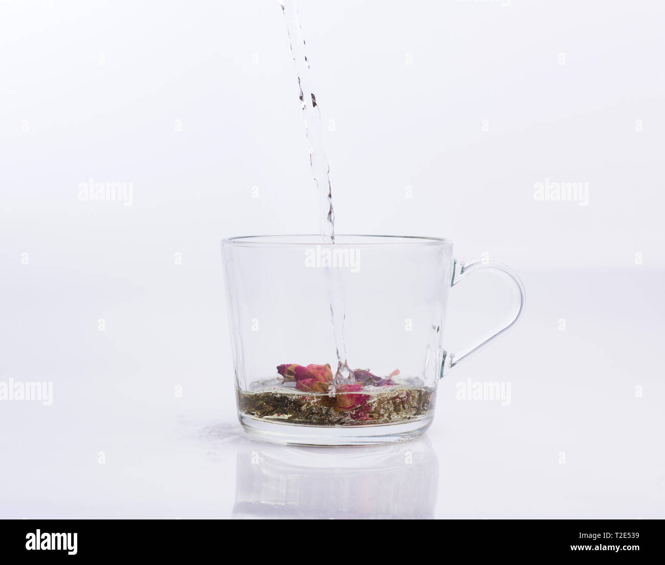 Tea pouring into glass cup isolated on white background Stock Photo - Alamy