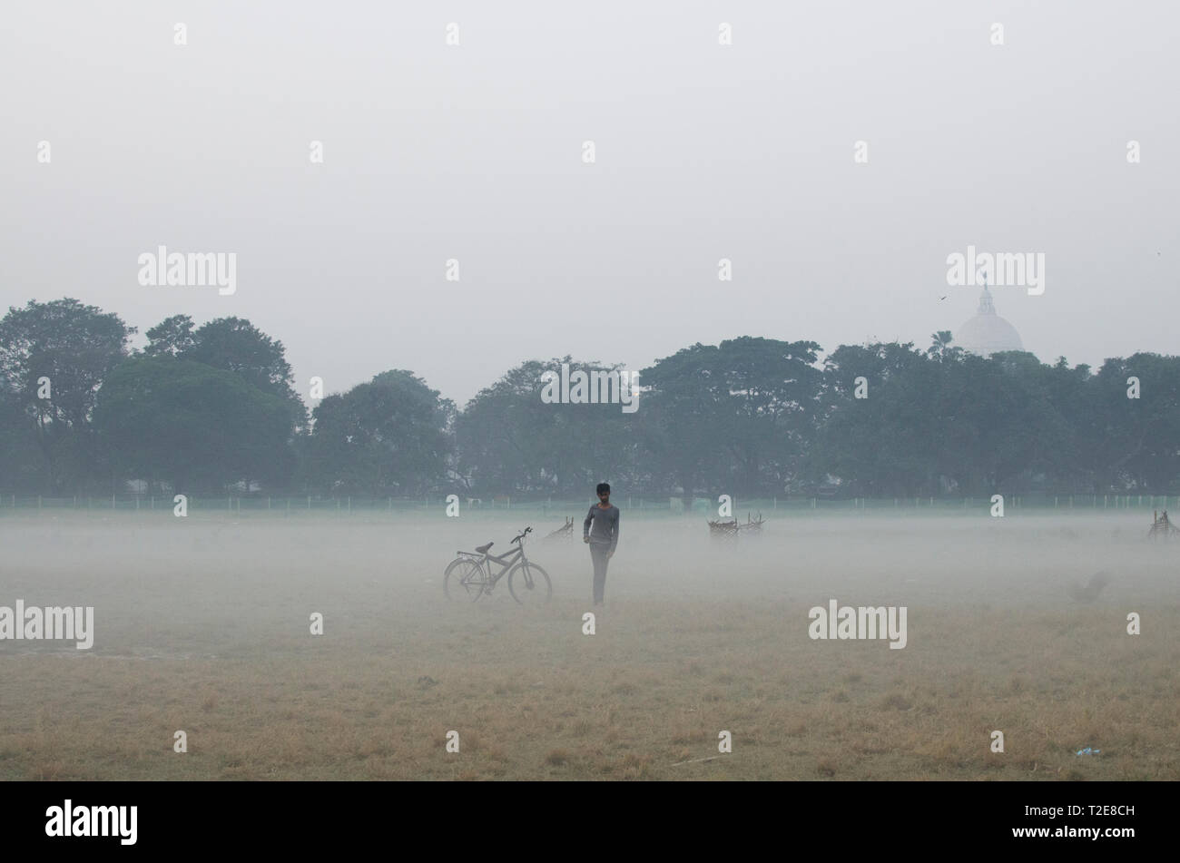 A boy walks in a foggy field at Maidan in Kolkata, India Stock Photo ...