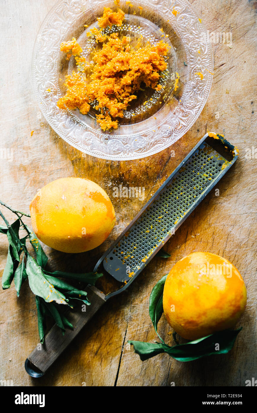 Orange zest, grating ornage zest from fresh fruit, top view with a zest ...