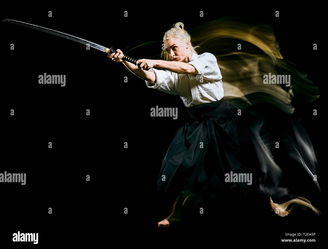 one budokas fighters woman practicing Iaido Kenjutsu studio shot ...