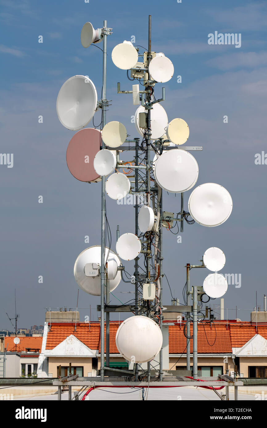 Telecommunication mast with microwave link on top roof at blue ...