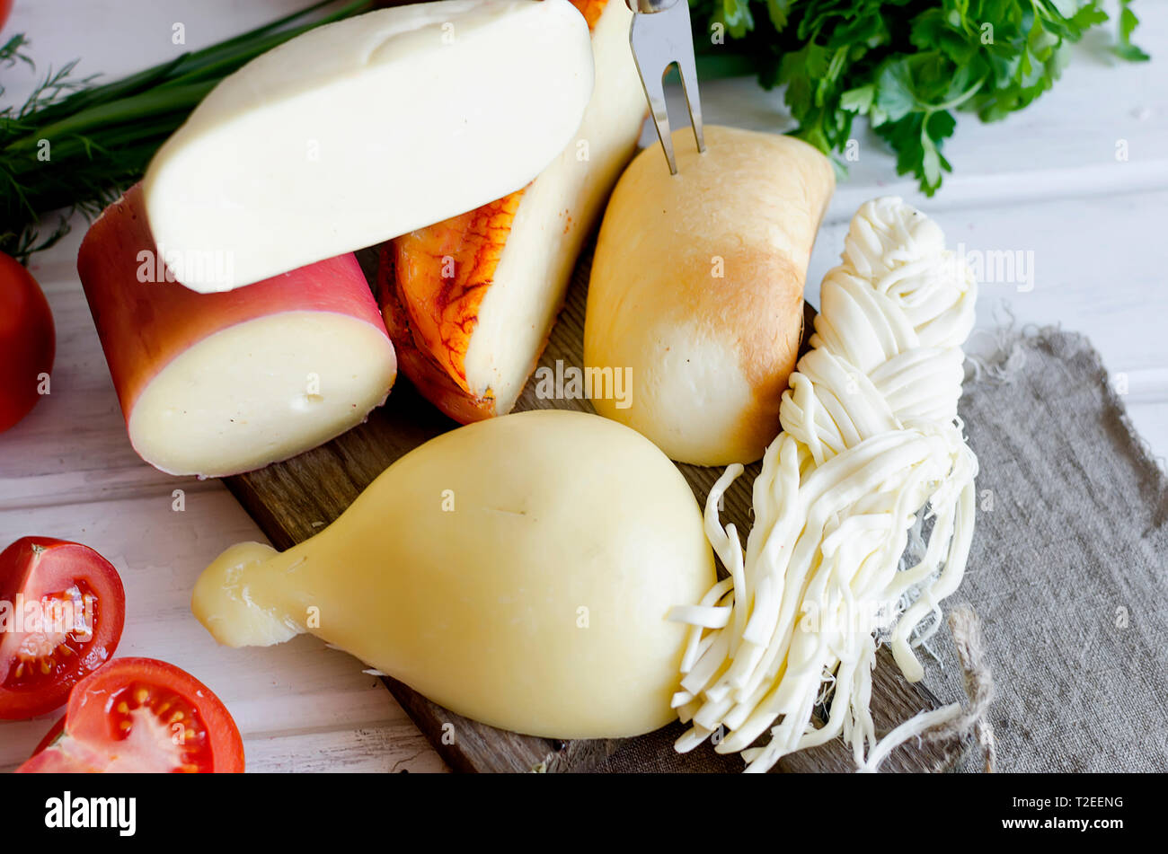 Assorted homemade cheeses in various shapes and sizes on the wooden ...