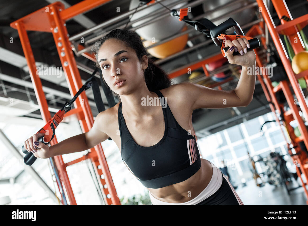 Young girl in gym sporty lifestyle concept total resistance workout ...