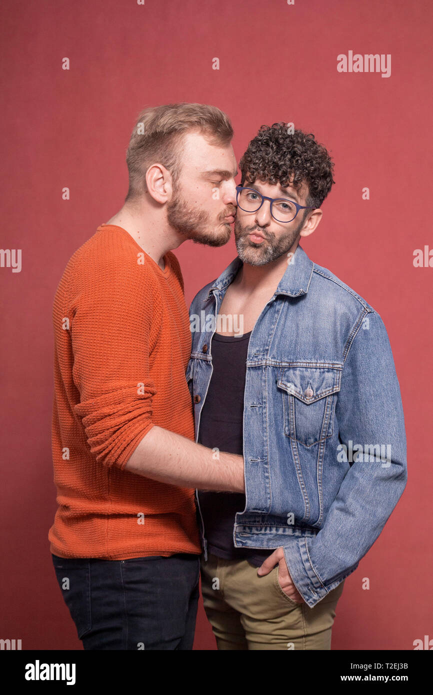 two men, gay couple making a face (kissing a camera) while being other ...