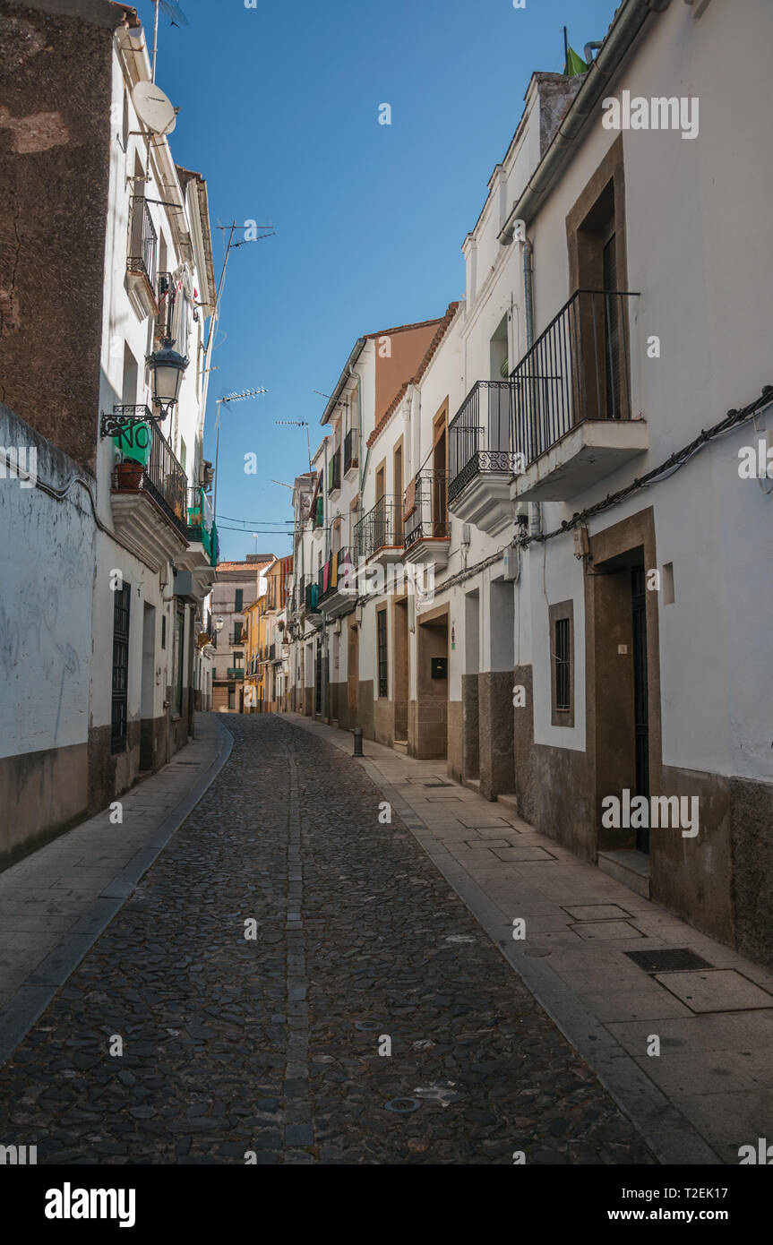Deserted alley with old terraced buildings with worn plaster in Caceres ...