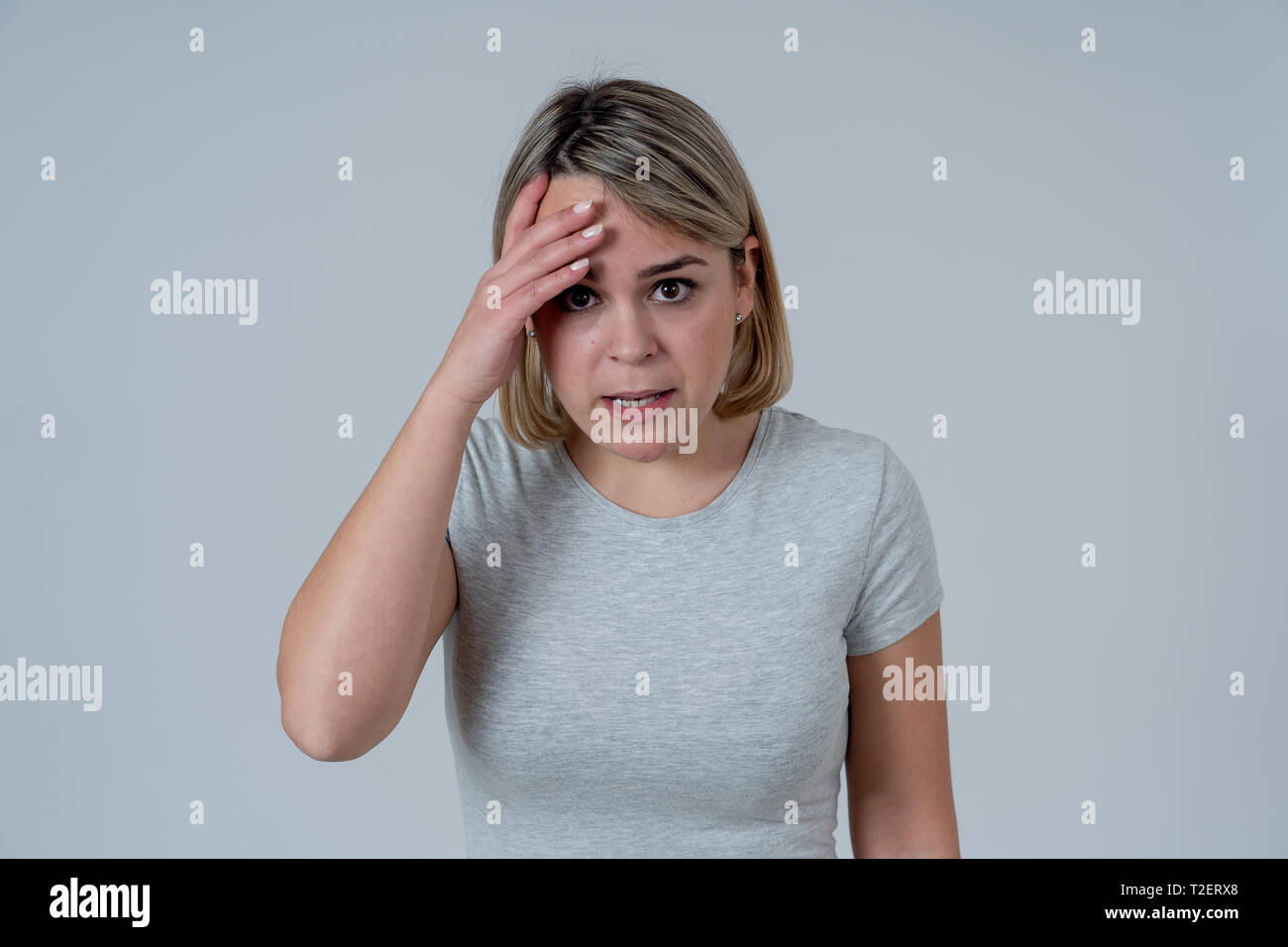 Close up portrait of young woman feeling afraid and shocked hiding her ...