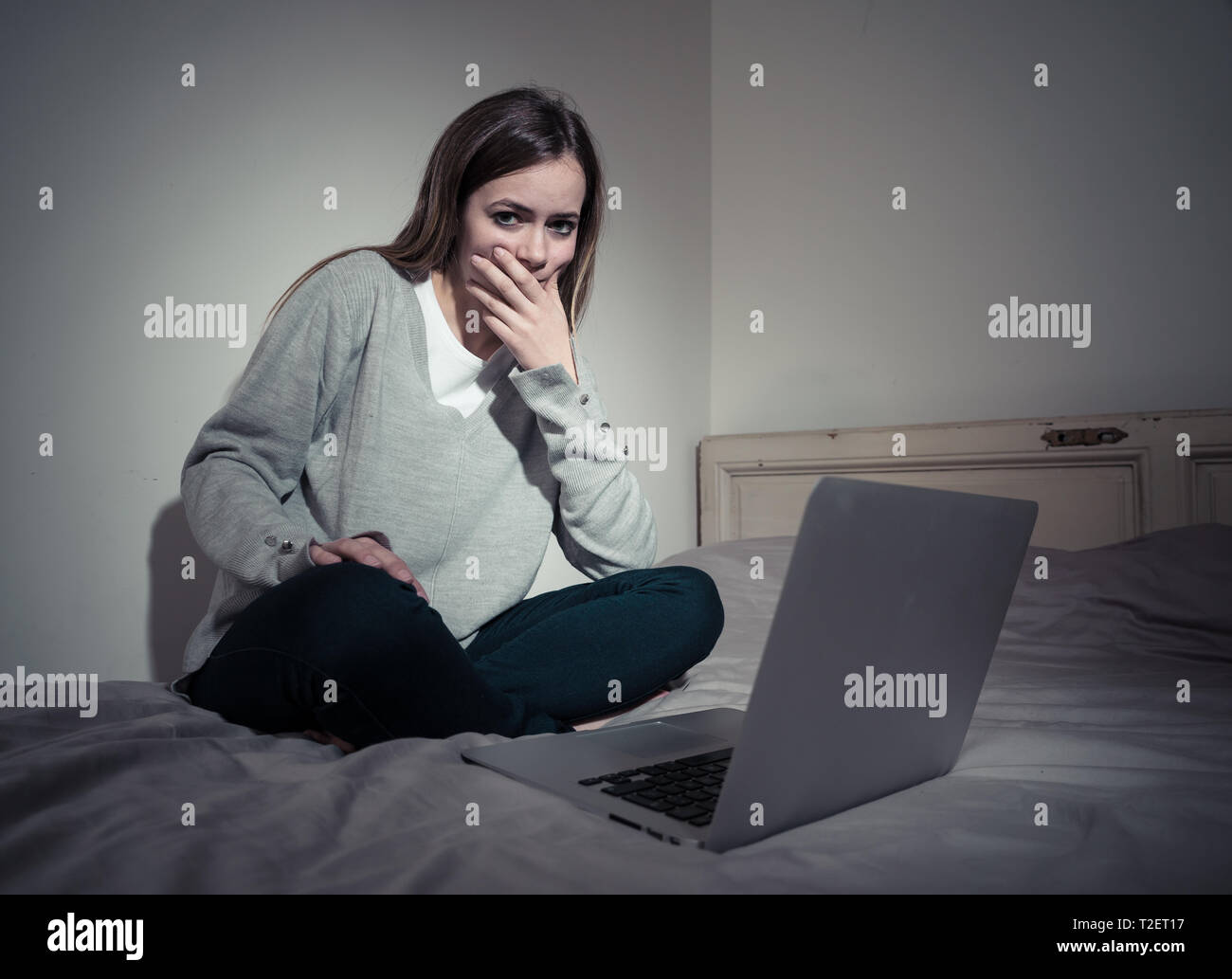 Scared and intimidated sad teenager bullied on line with laptop ...
