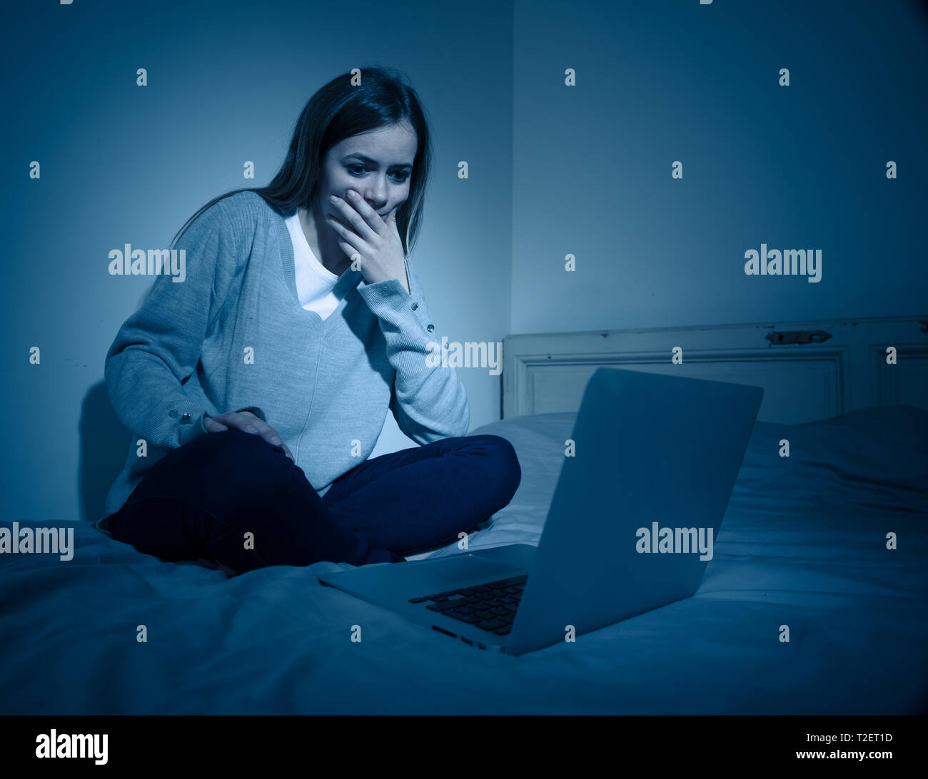 Scared and intimidated sad teenager bullied on line with laptop ...