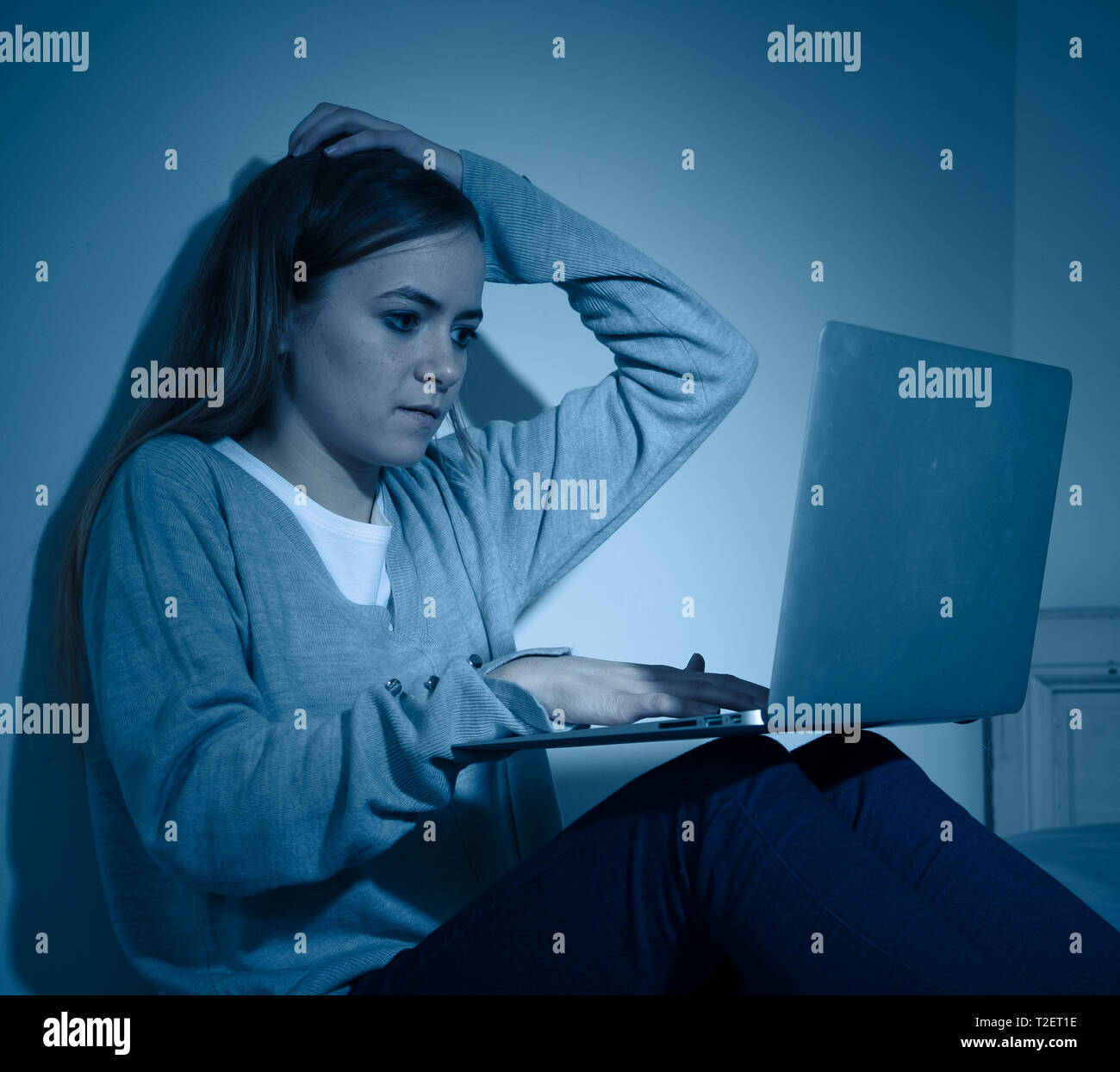 Scared and intimidated sad teenager bullied on line with laptop ...