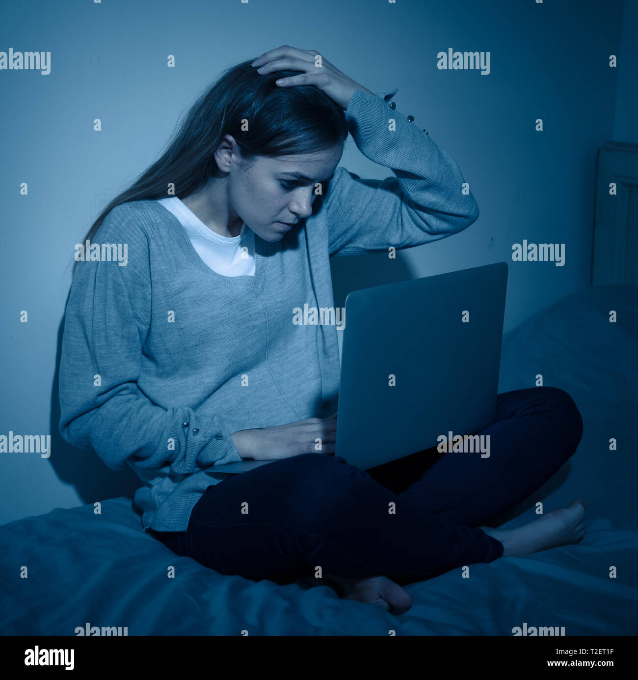 Scared and intimidated sad teenager bullied on line with laptop ...