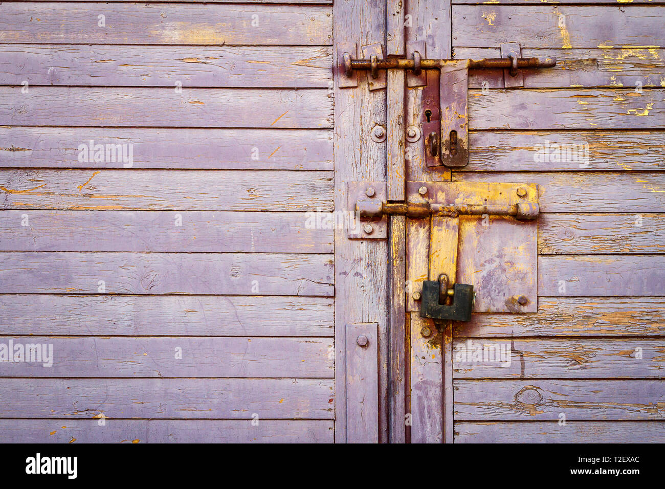 Old lilac color wooden plank door with padlock. Architecture detail ...