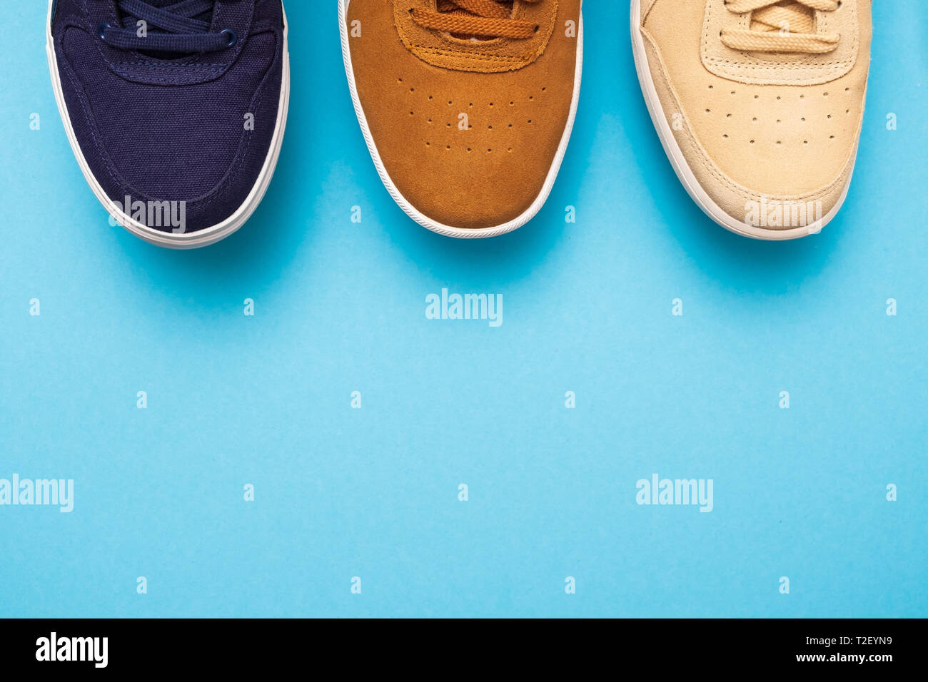 Three pair of sneakers on colored background in row. Flat lay, top view ...