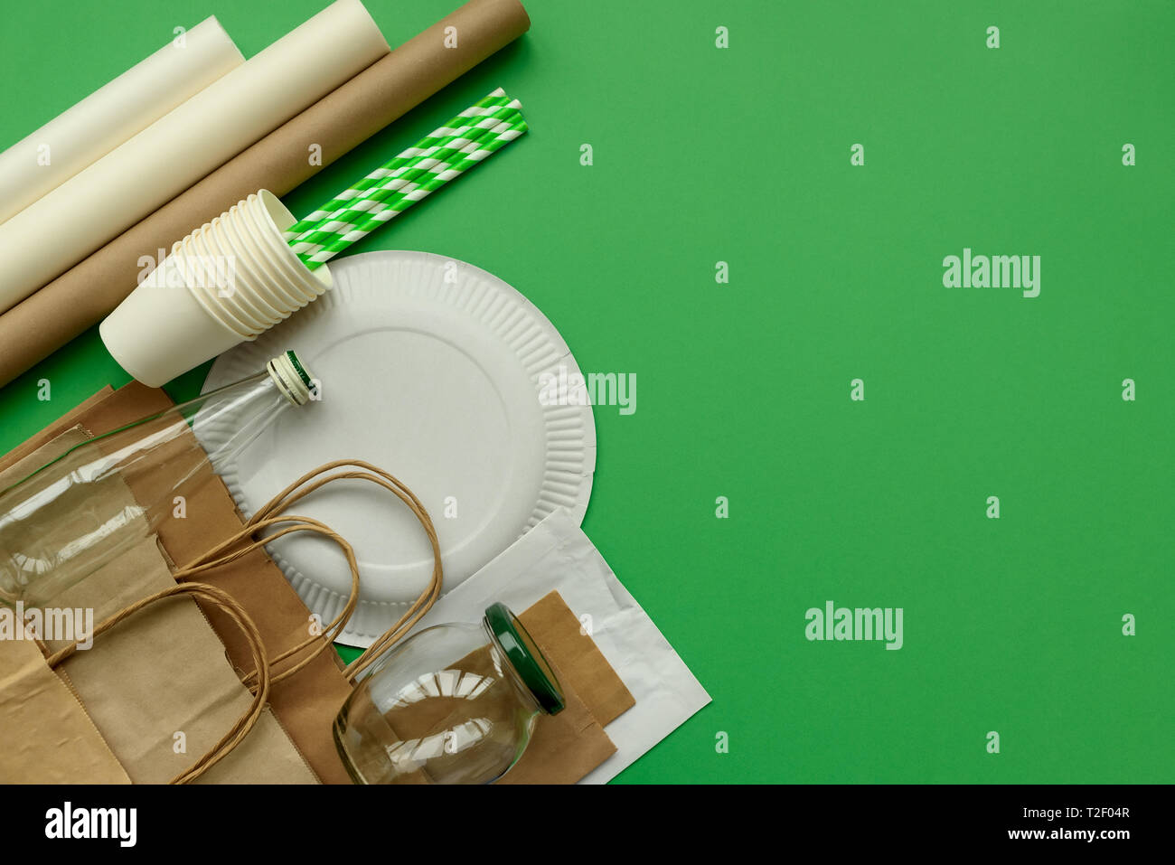 Paper and glass packages on green background. Copy space. Top view. Eco ...