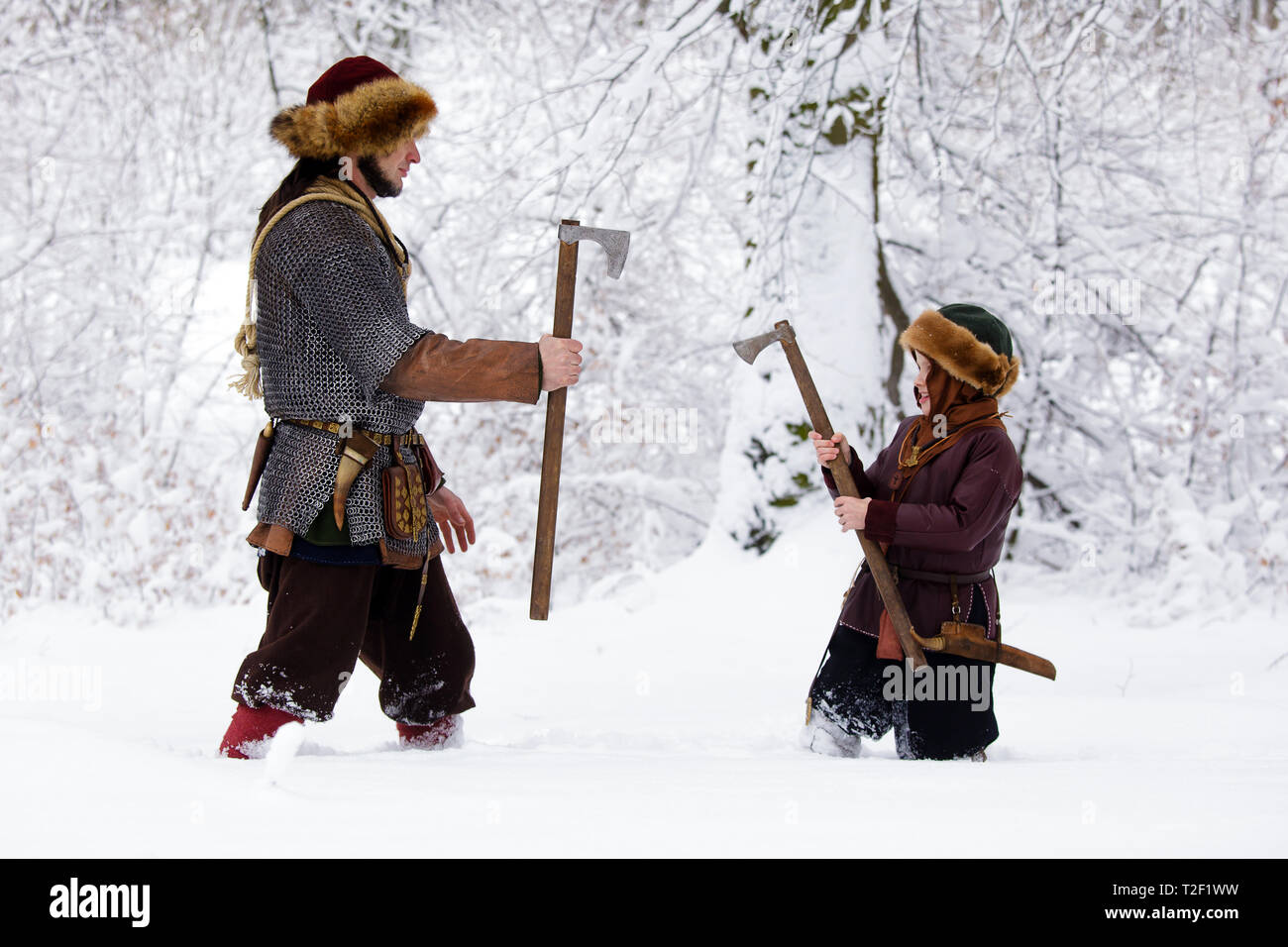 Father and son Vikings in a deep winter forest and the father teaches ...