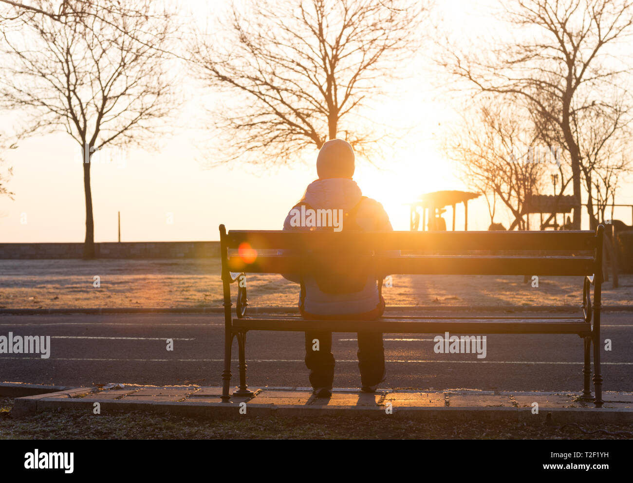 silhouette of woman on bench alone at sunrise Stock Photo - Alamy