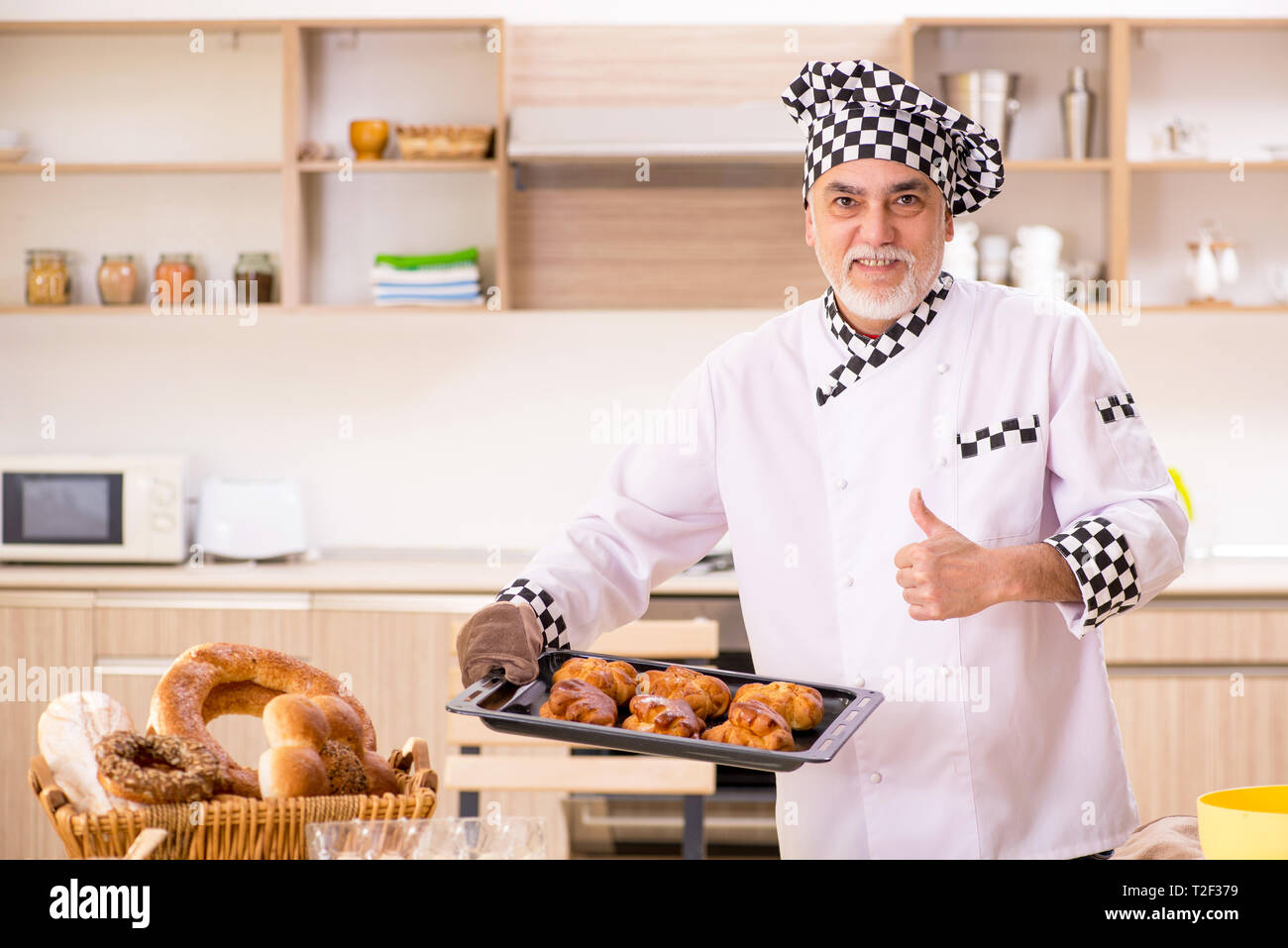 Old male baker working in the kitchen Stock Photo - Alamy