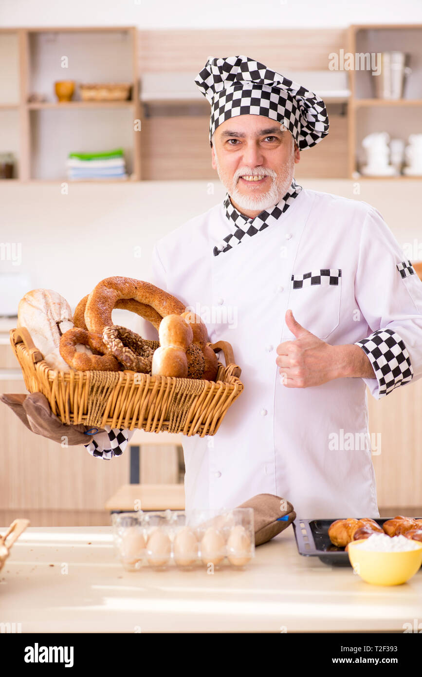 Old male baker working in the kitchen Stock Photo - Alamy