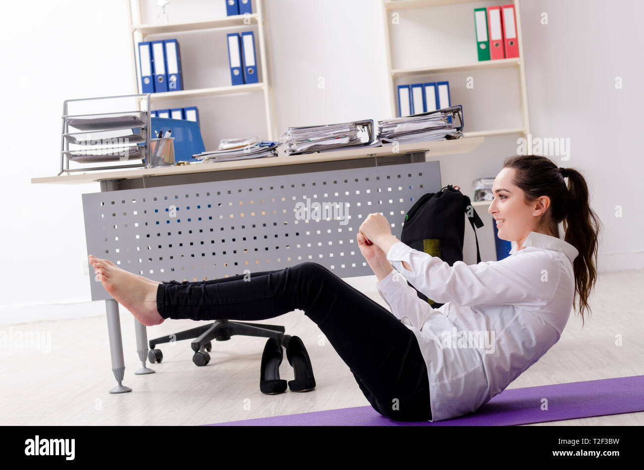 Female employee doing sport exercises in the office Stock Photo - Alamy