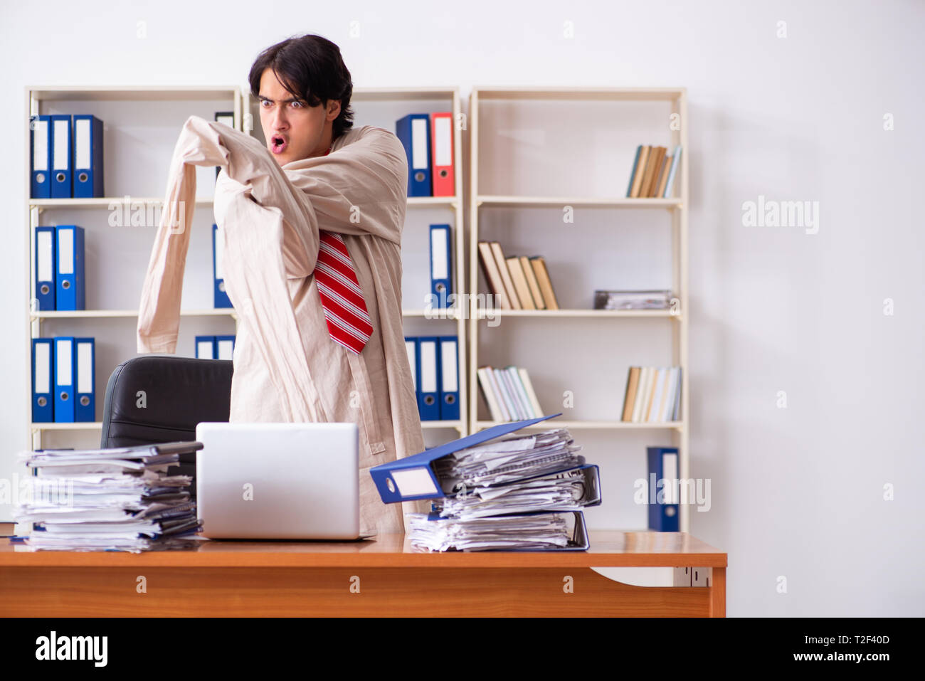 Crazy young man in straitjacket at the office Stock Photo - Alamy