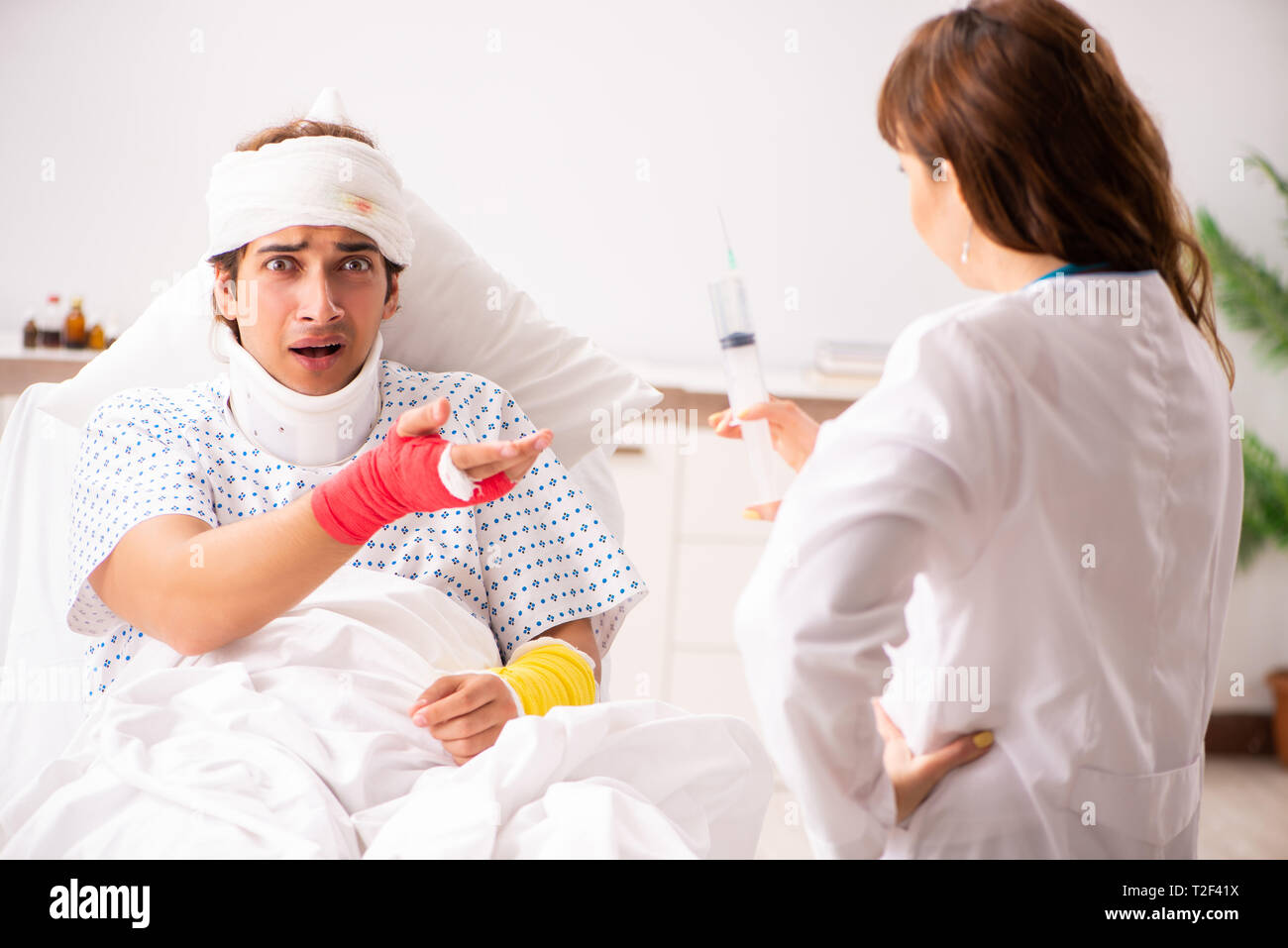 Young doctor examining injured patient Stock Photo - Alamy