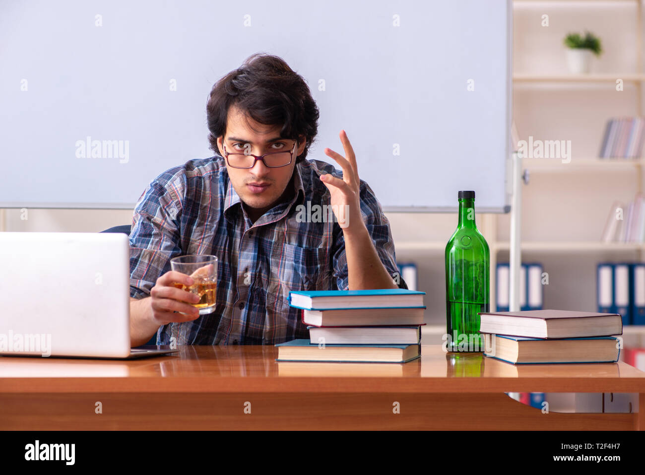 Male teacher drinking in the classroom Stock Photo - Alamy