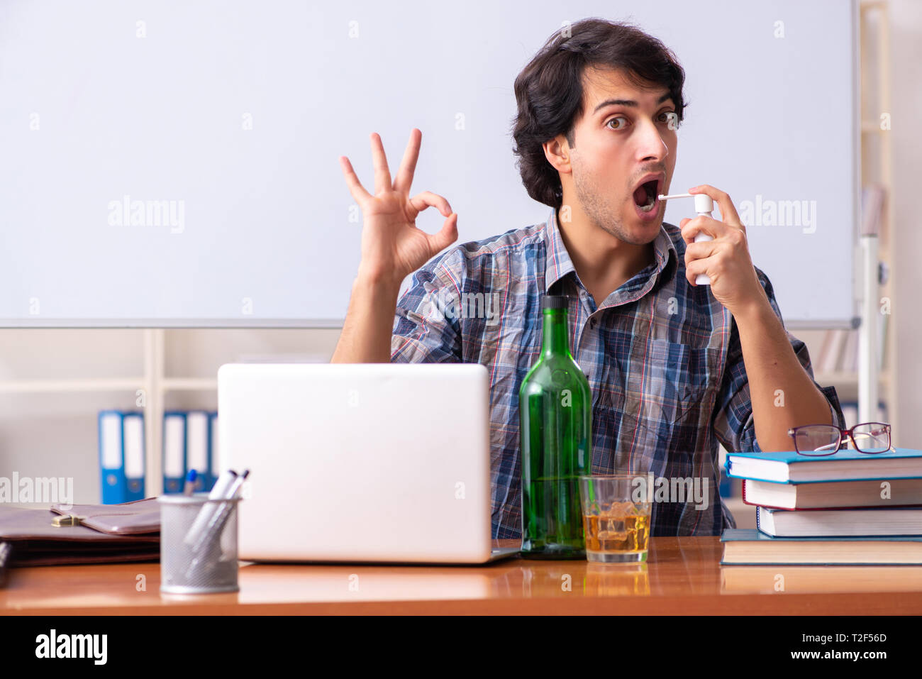 Male teacher drinking in the classroom Stock Photo - Alamy
