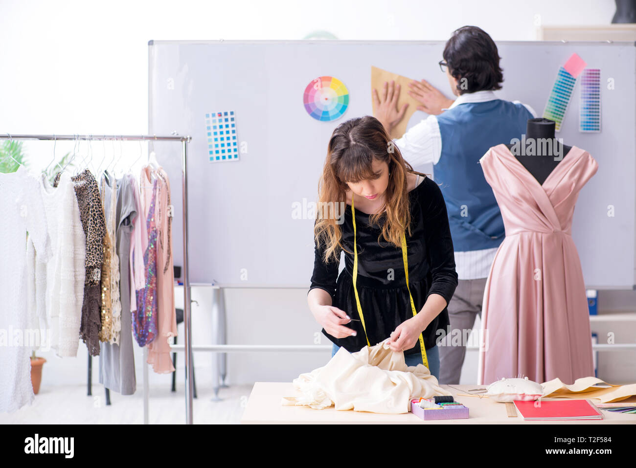 Young male tailor teaching female student Stock Photo - Alamy