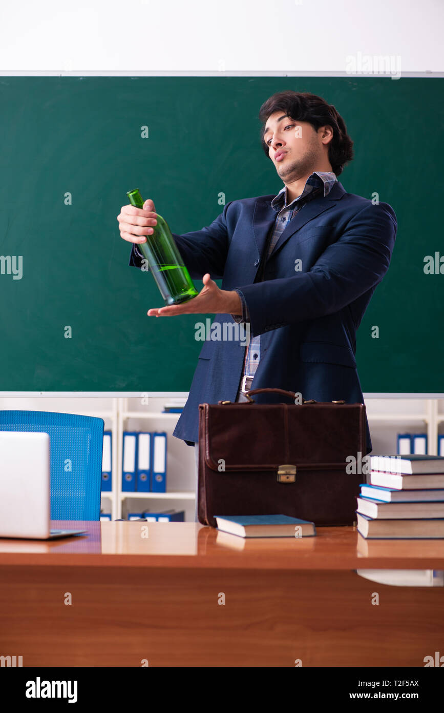 Male teacher drinking in the classroom Stock Photo - Alamy