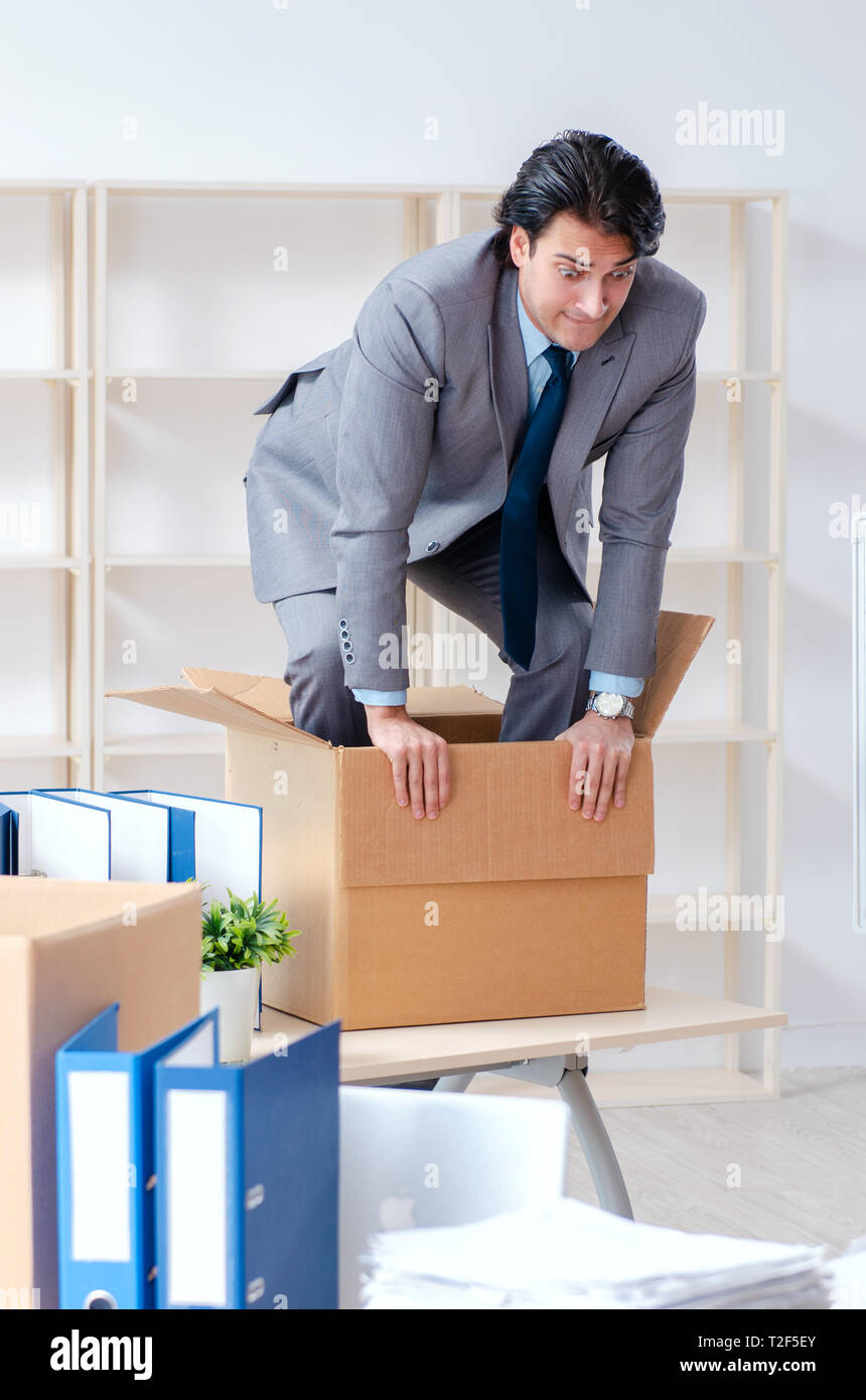 Young man employee with boxes in the office Stock Photo - Alamy