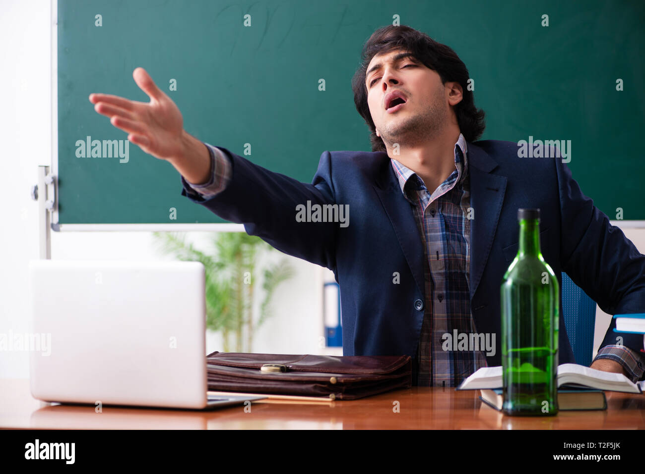 Male teacher drinking in the classroom Stock Photo - Alamy