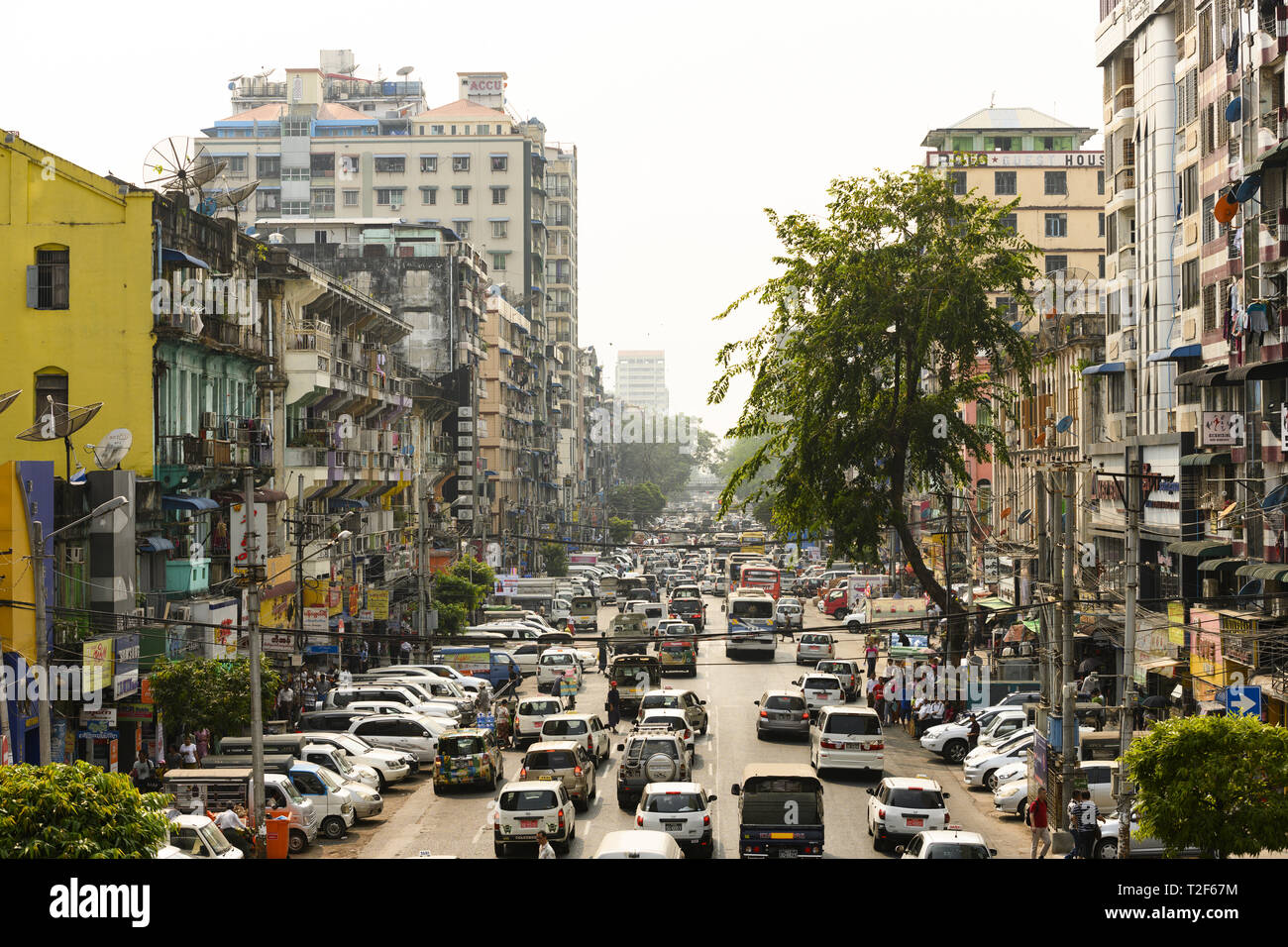 Daily traffic and city life on the busy streets of Yangon during sunset ...