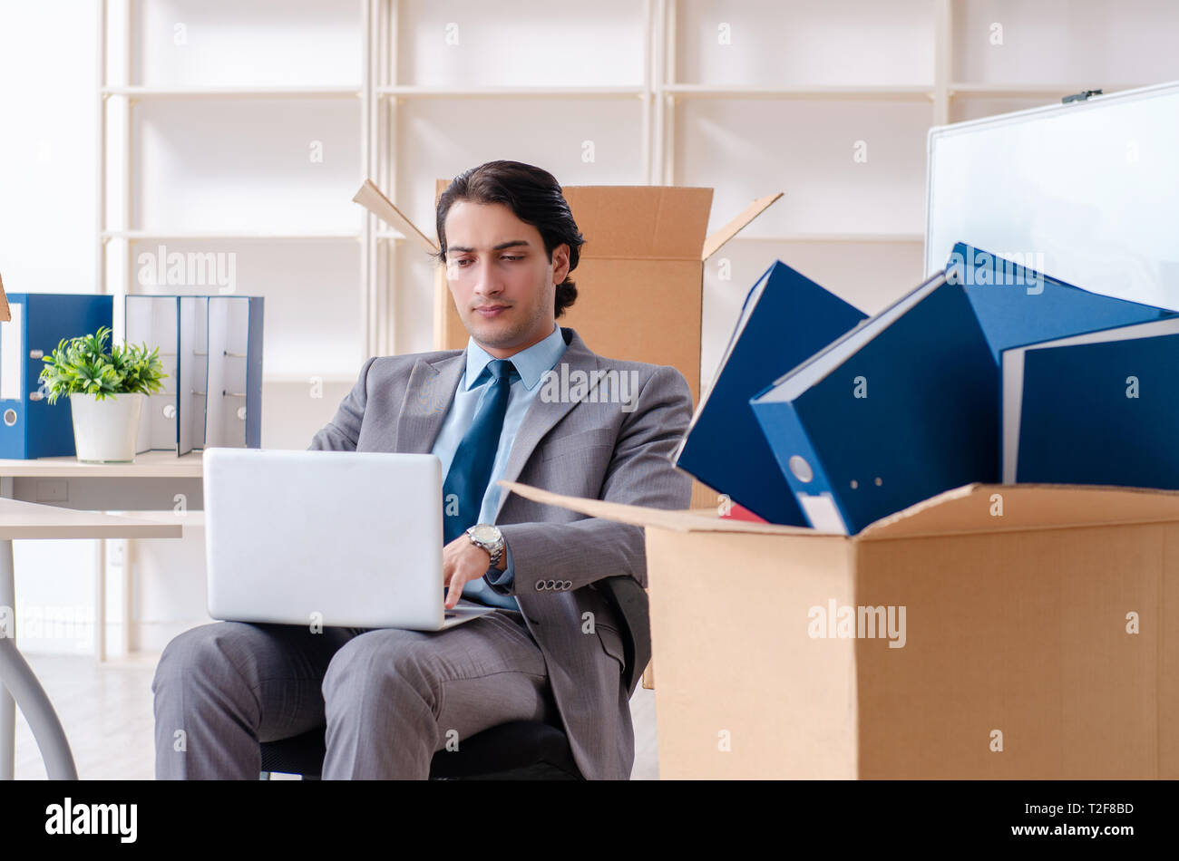 Young man employee with boxes in the office Stock Photo - Alamy