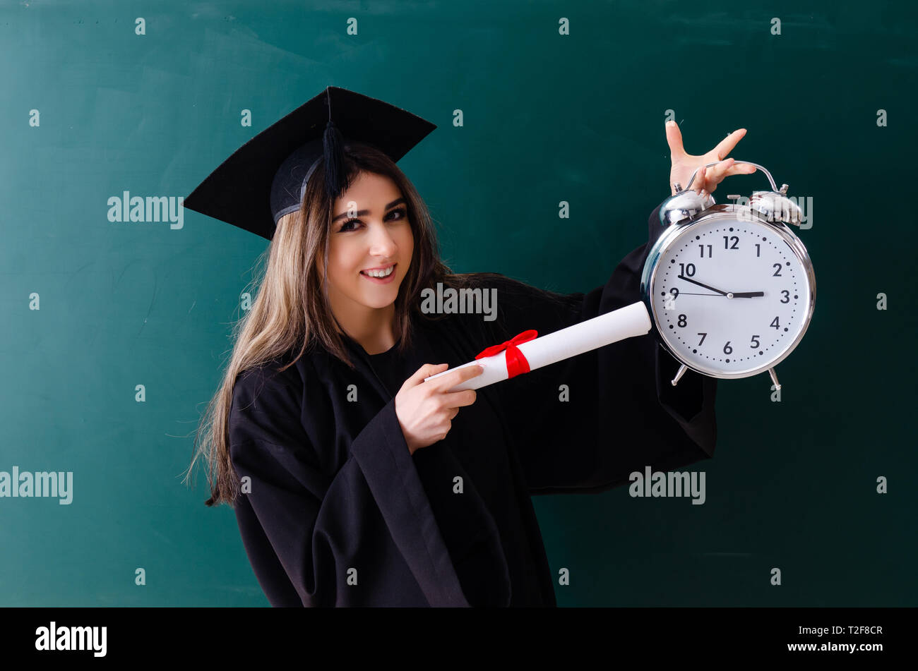 Female graduate student in front of green board Stock Photo - Alamy