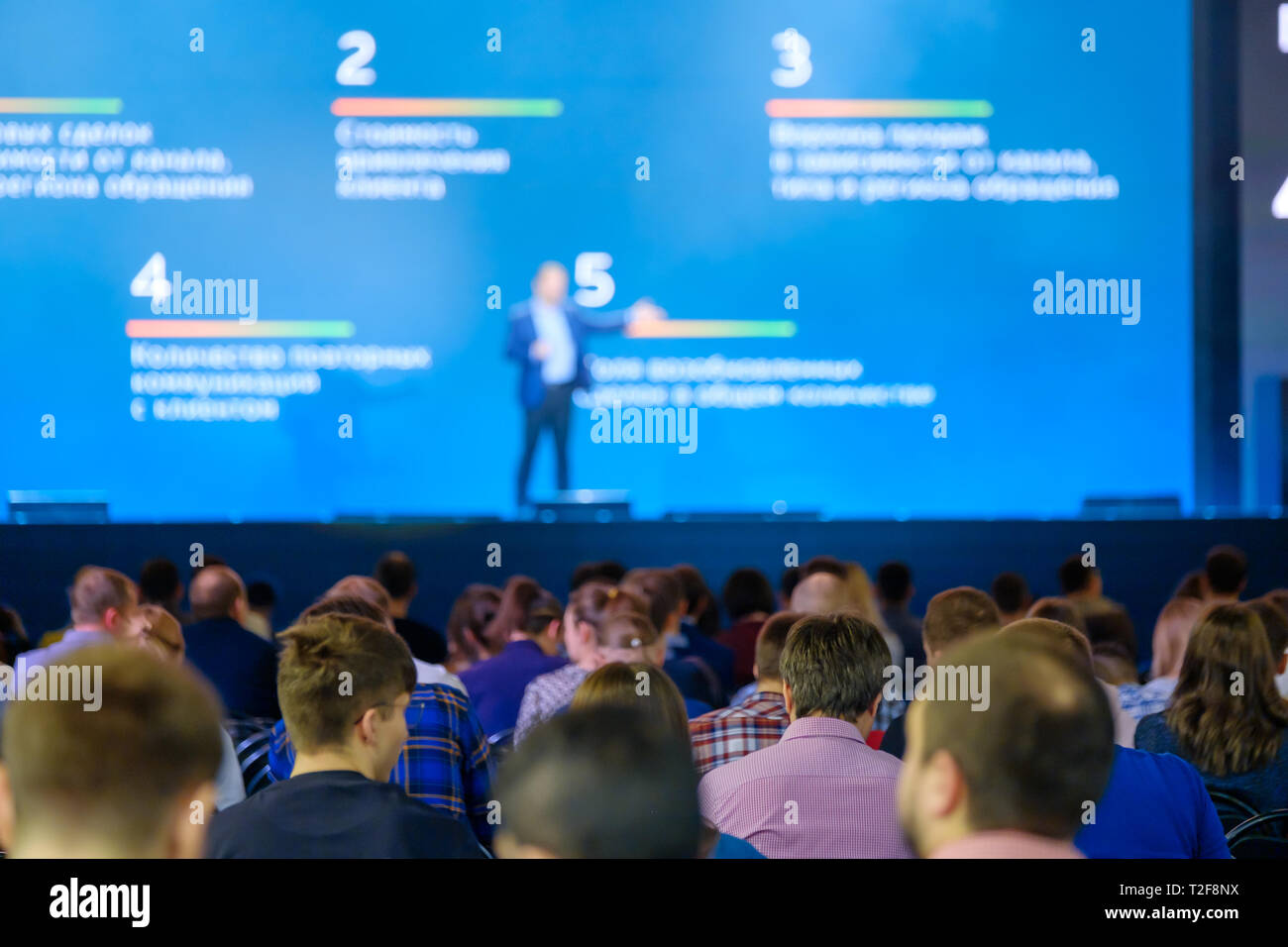 Audience listens to the lecturer at the business conference, back view ...