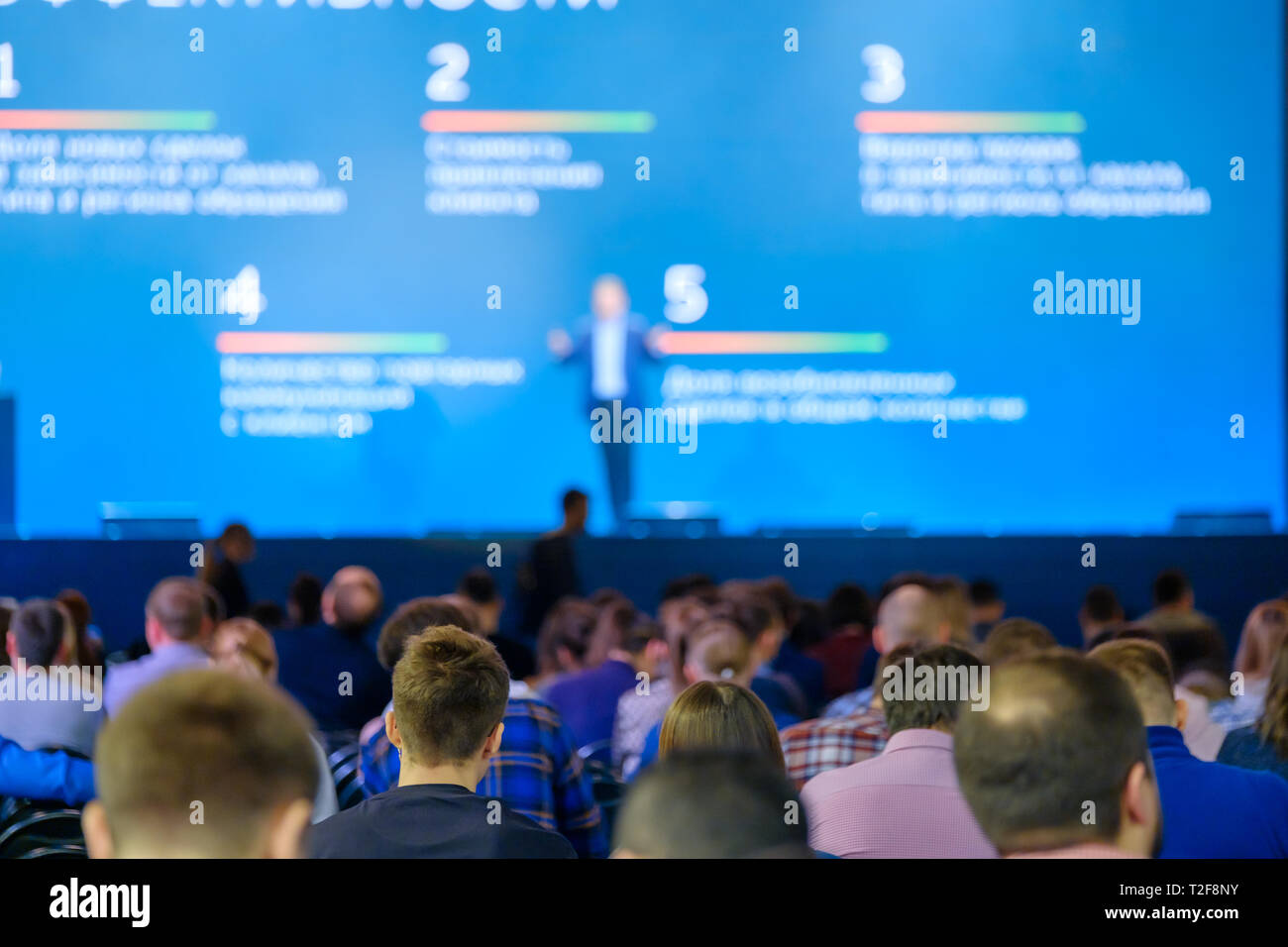 Audience listens to the lecturer at the business conference, back view ...