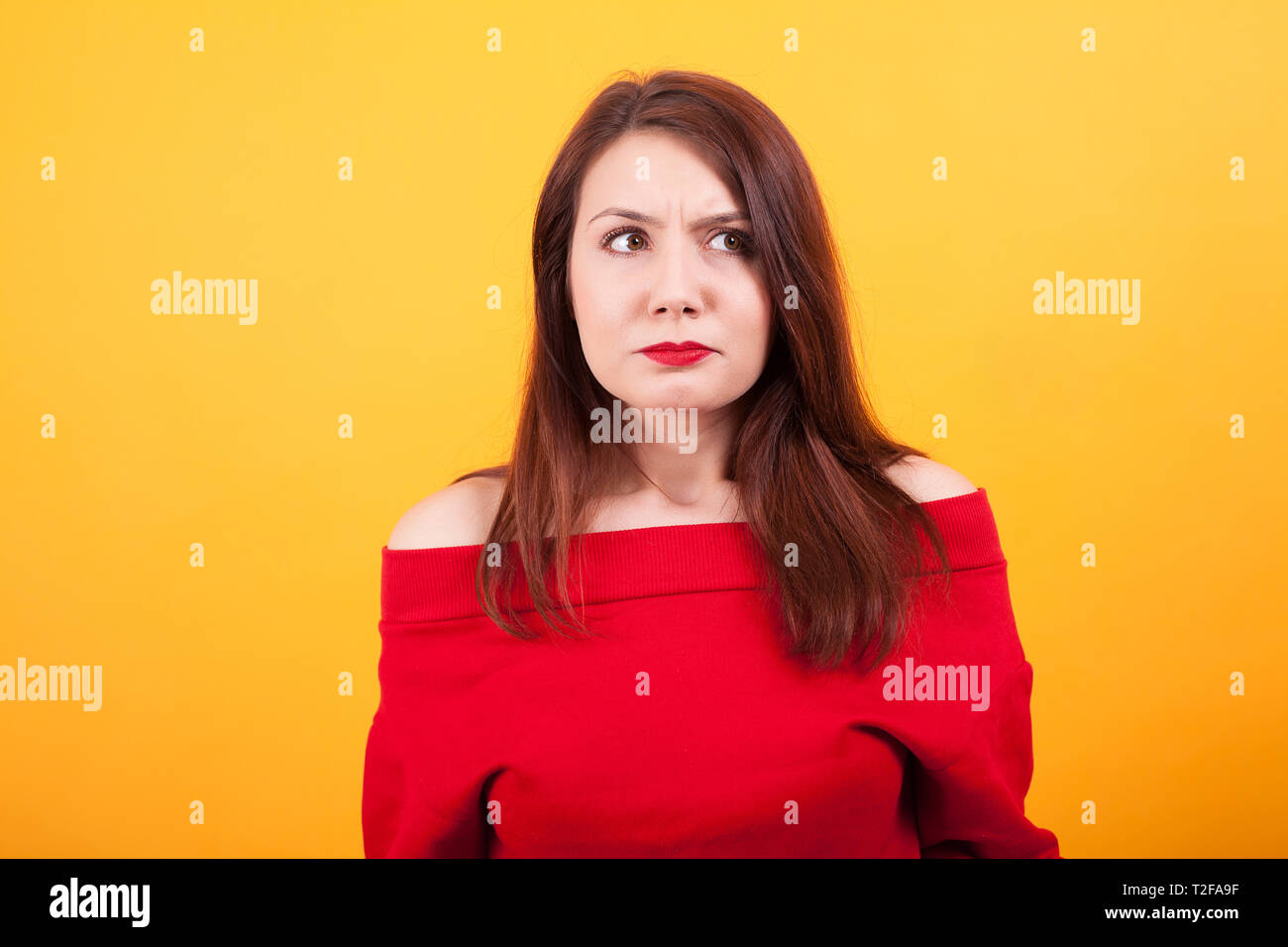 Lovely confused woman looking away over yellow background. Beautiful ...