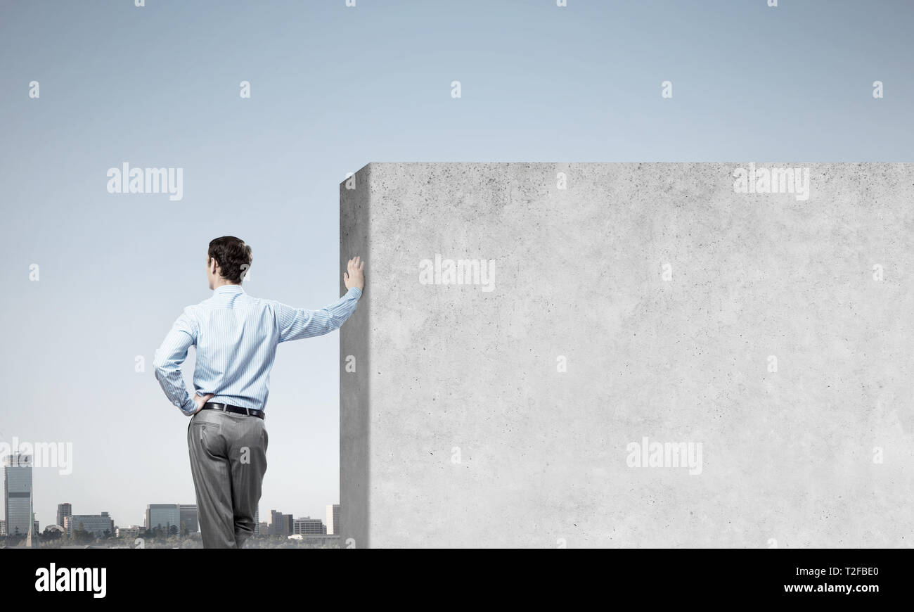 Businessman standing with back and leaning on cement blank wall Stock ...