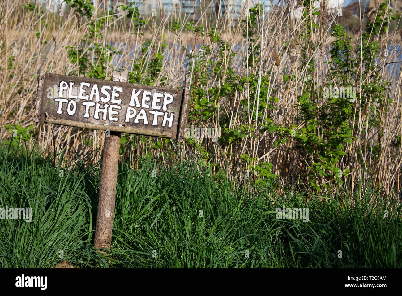 Please keep to the path sign at nature reserve Stock Photo - Alamy