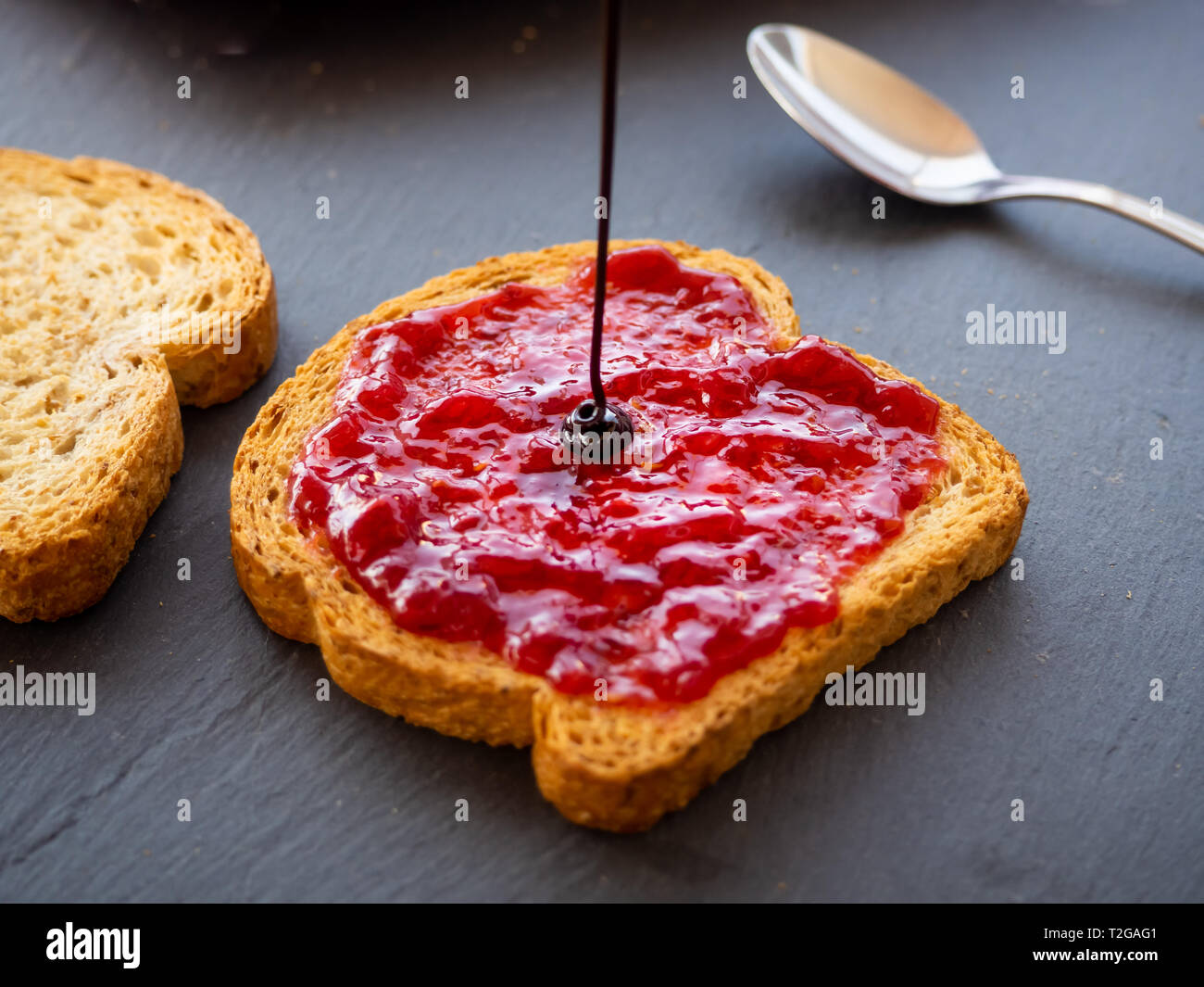 Pouring chocolate syrup on a slice of toast with raspberry jam Stock ...