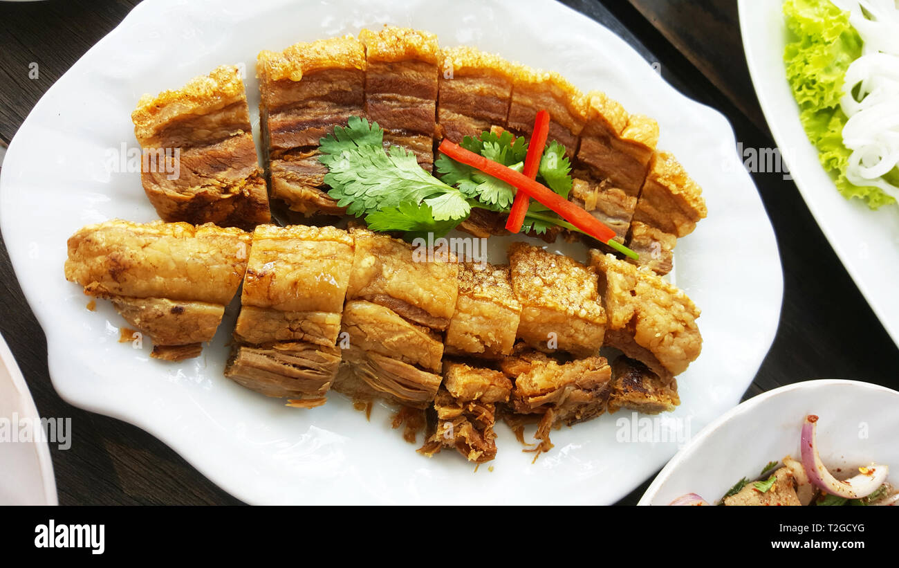 crispy roasted pork on white plate on table Stock Photo - Alamy