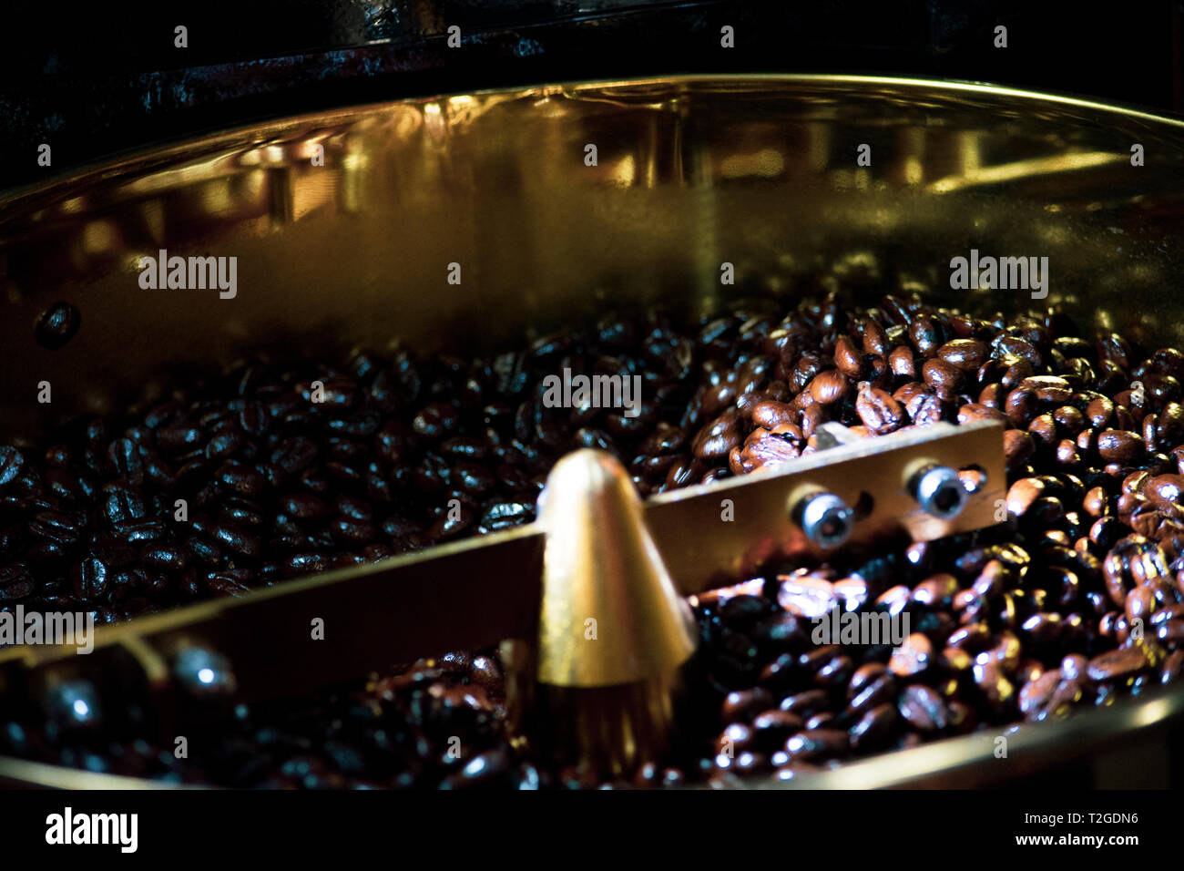 Roasted coffee in coffee roaster, Machine for roasting coffee close up ...