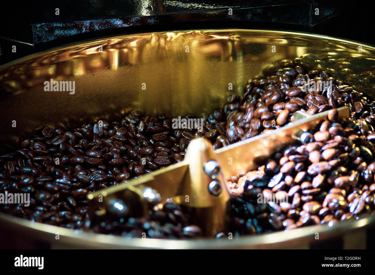 Roasted coffee in coffee roaster, Machine for roasting coffee close up ...