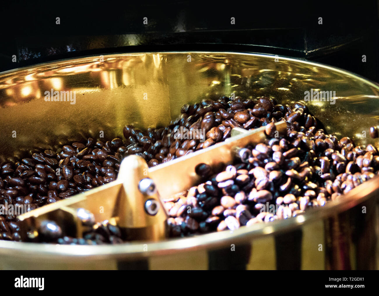 Roasted coffee in coffee roaster, Machine for roasting coffee close up ...