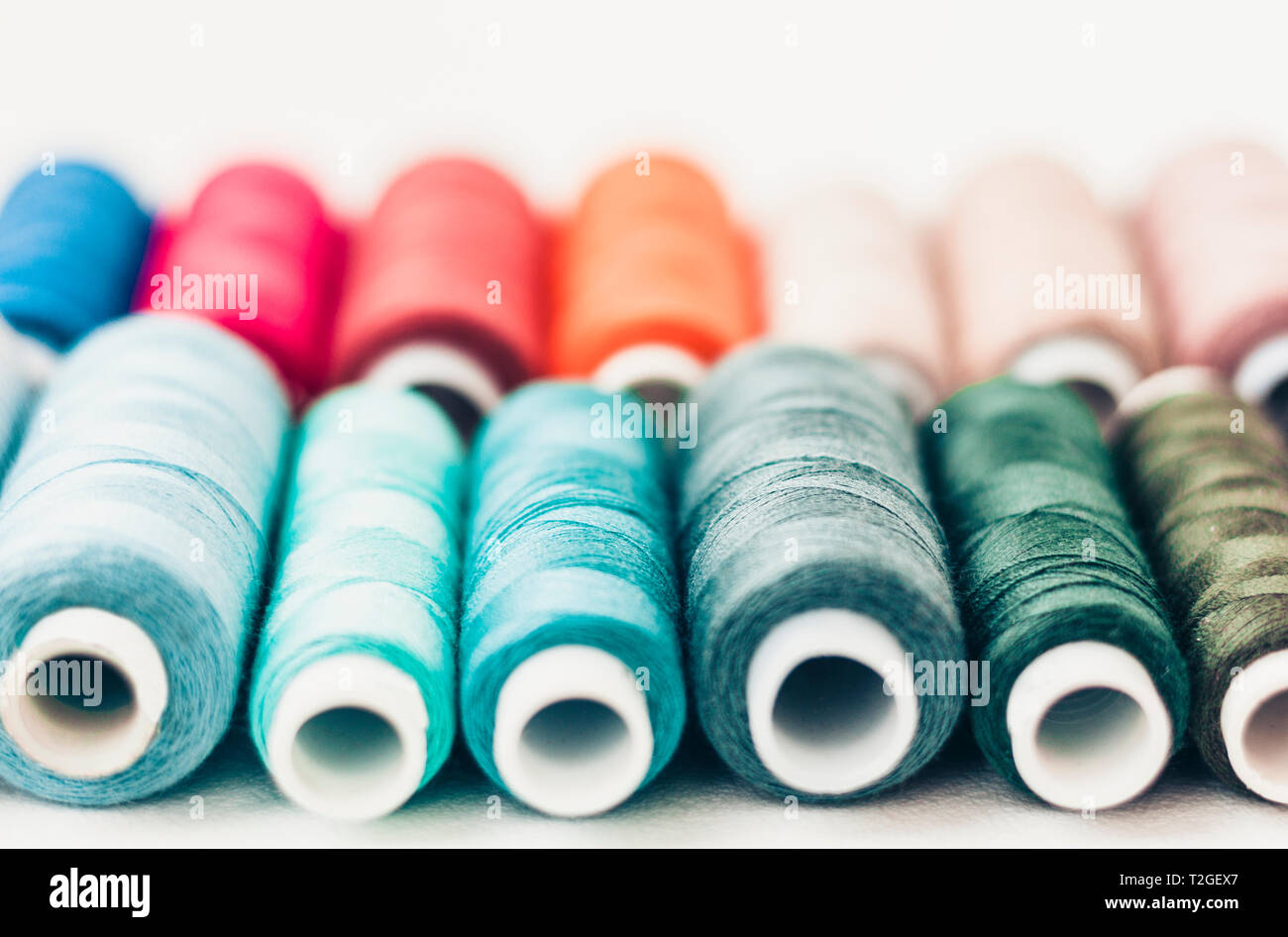 Colored sewing thread coils on white background with copy space for ...