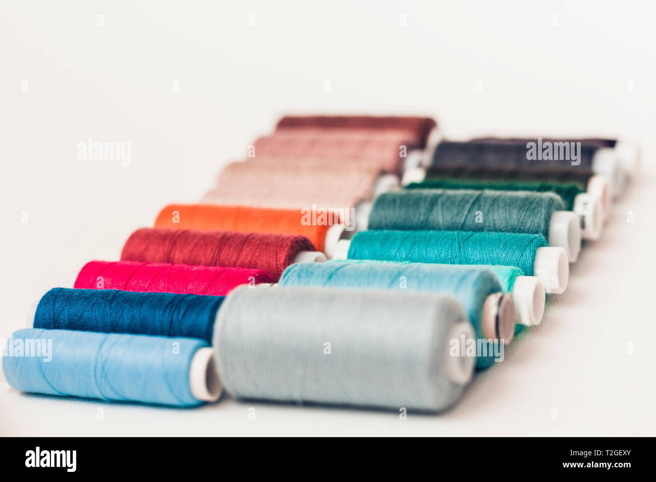 Colored sewing thread coils on white background with copy space for ...