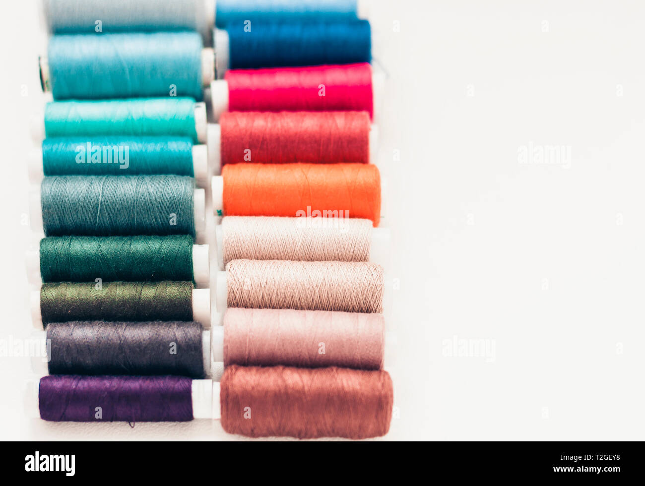 Colored sewing thread coils on white background with copy space for ...
